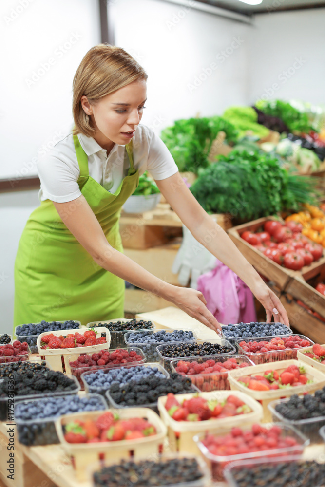 Young shop assistant working at market Stock Photo | Adobe Stock