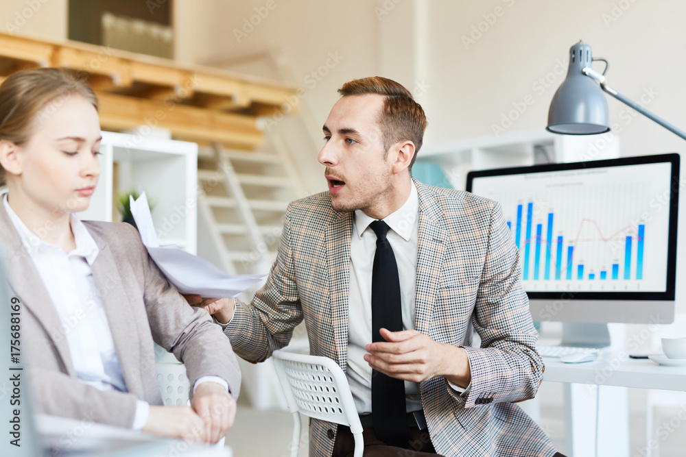 Annoyed boss with papers scolding his subordinate in office Stock Photo ...