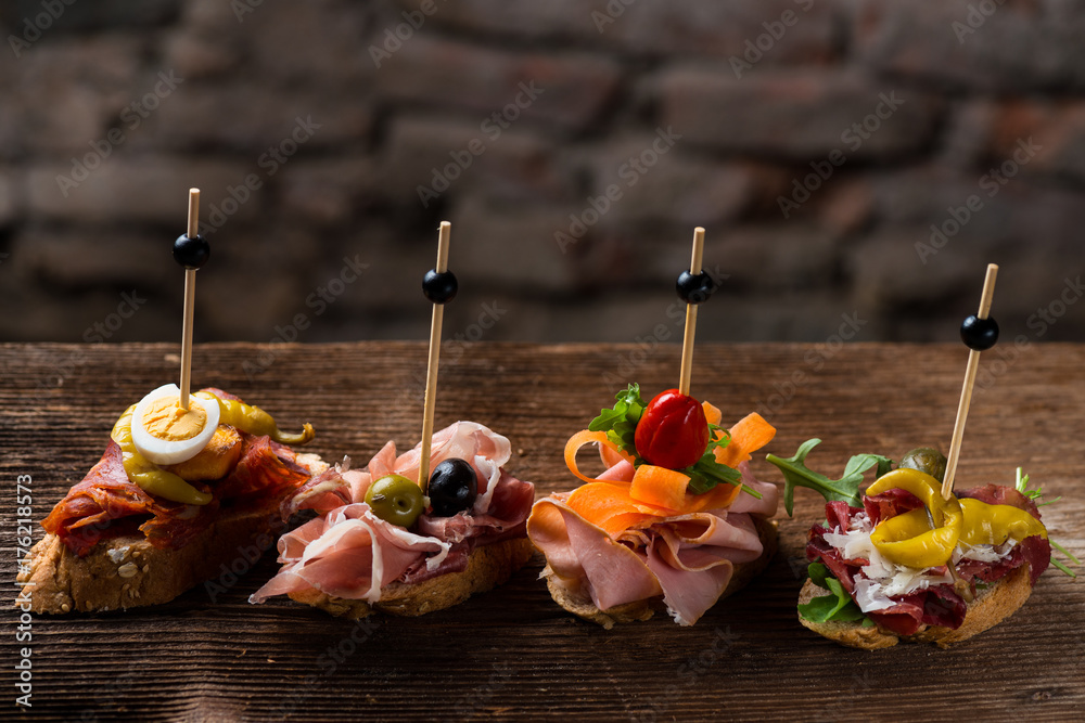 Tapas on Crusty Bread - Selection of Spanish tapas served on a sliced ...