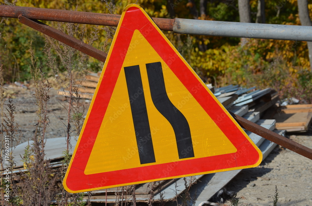 crooked road sign hanged at the entrance to the road with the backdrop ...