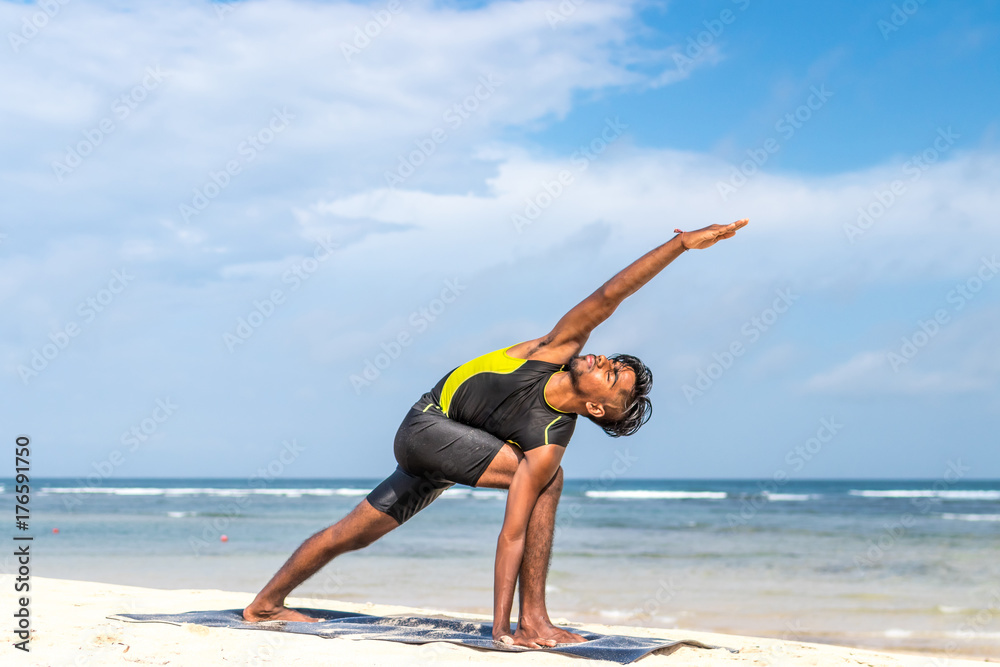Asian yoga man practice yoga on the beach with a clear blue sky ...