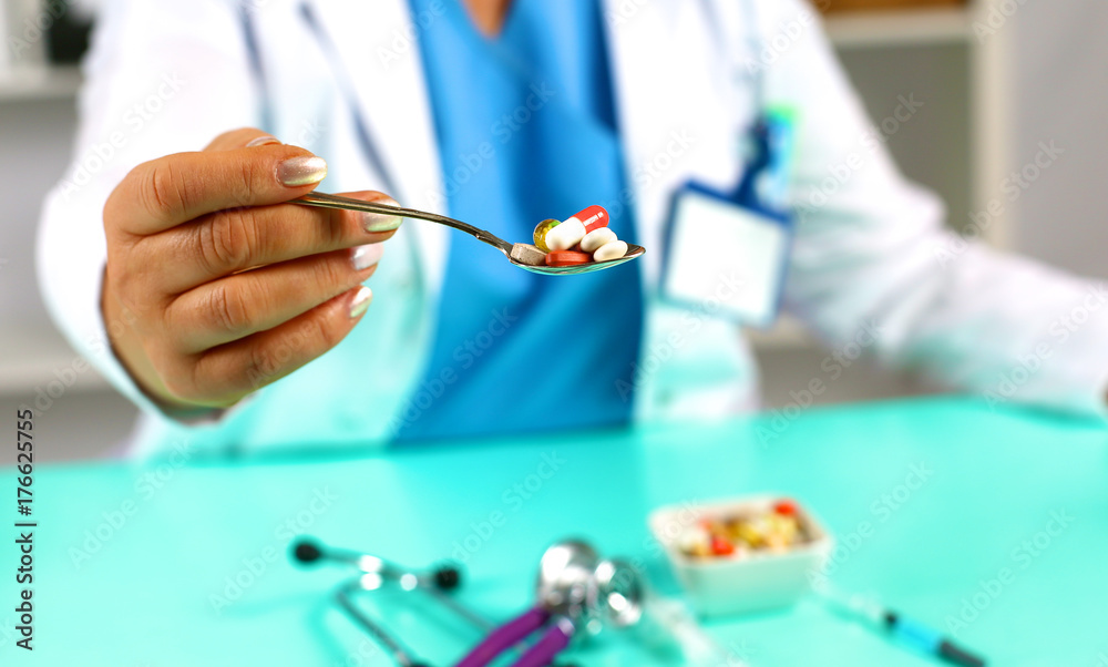 Female doctor hand hold pack of different tablet blisters at workplace ...