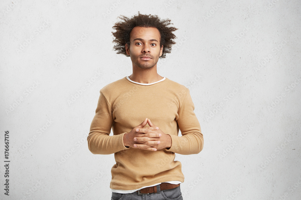 Indoor shot of confident mixed race businessman dressed casually, keeps ...