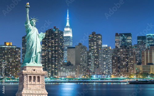 The Statue of Liberty with cityscape in Manhattan at night, New York ...