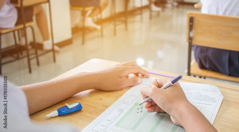 Uniform School Asian students taking exams writing answer optical form ...