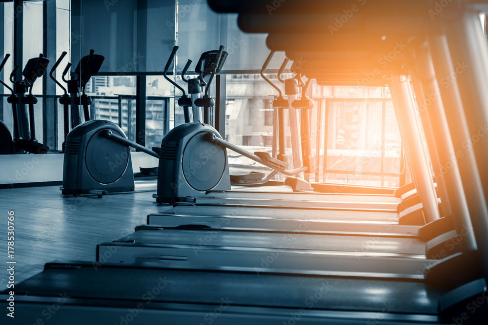 treadmill in fitness room background with color tone and light flare ...