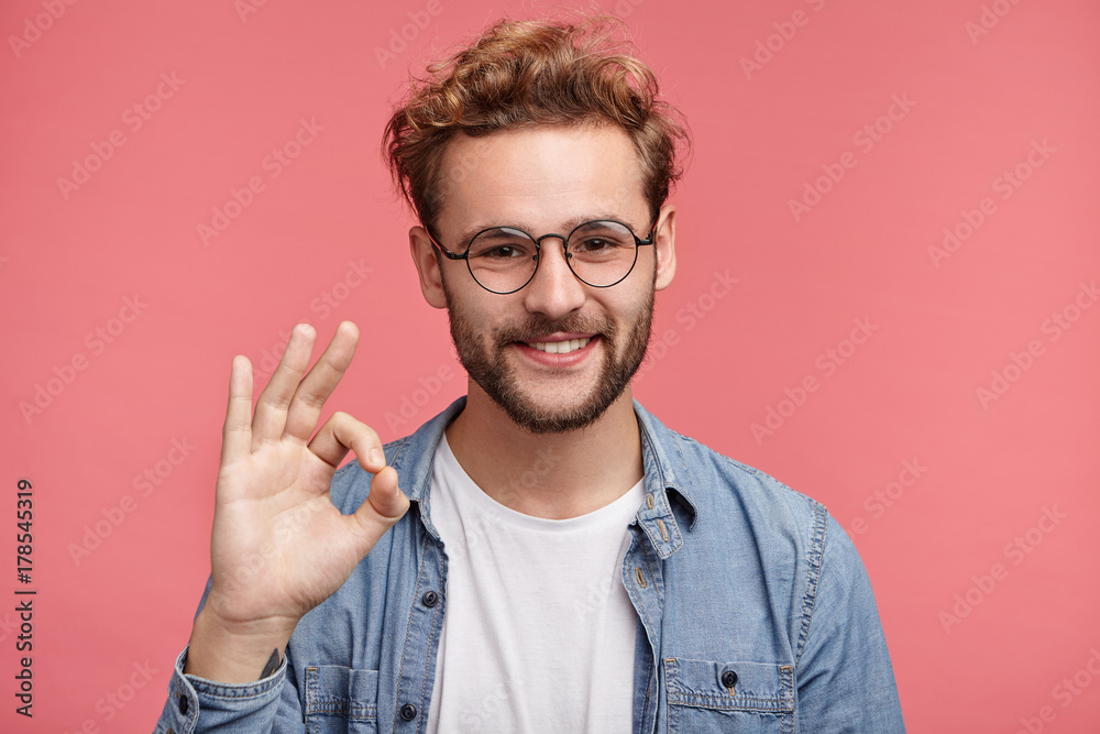 Positive hipster guy shows ok sign, demonstares that everything is fine ...