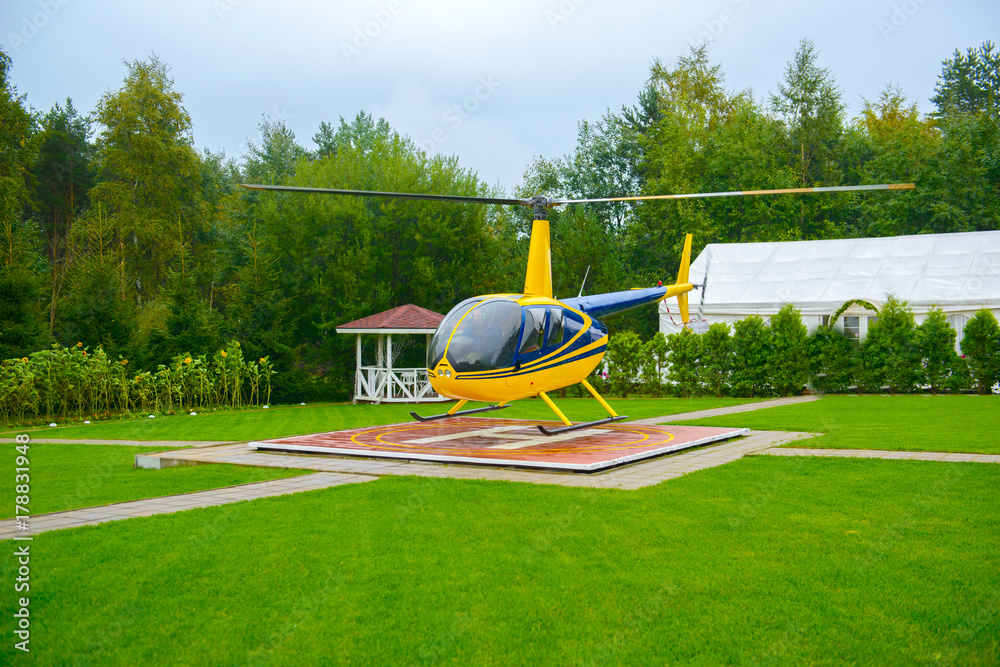 Yellow helicopter sits on a heliport - Air transport in sky. Useful ...