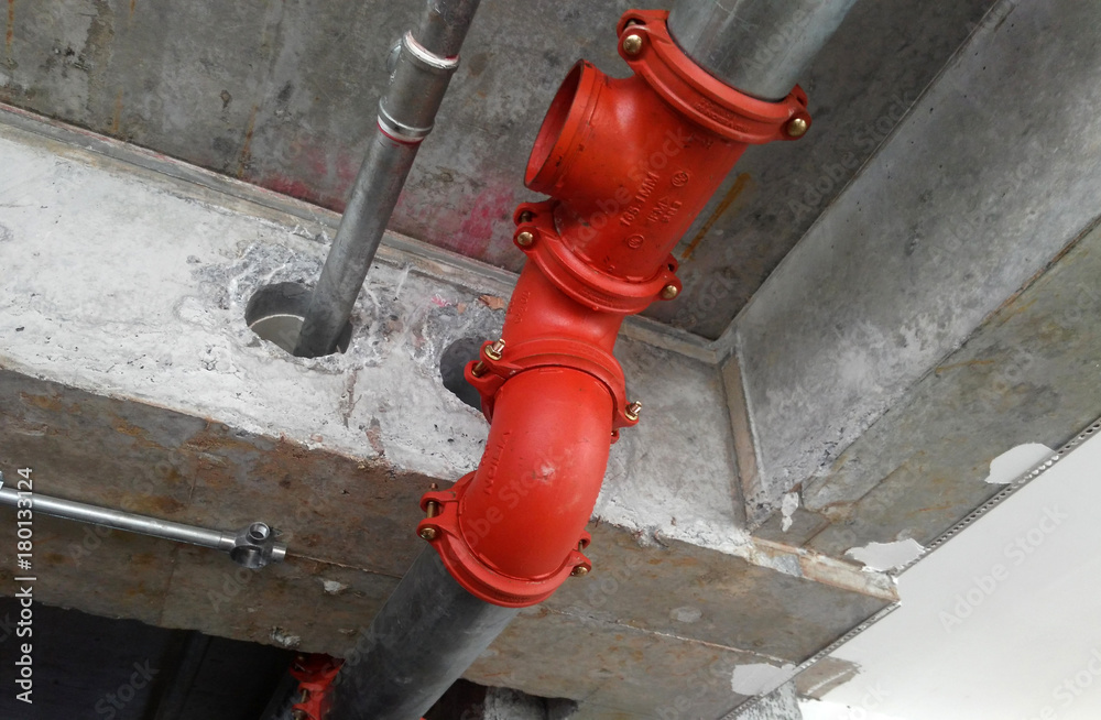Sprinkler system pipe in hang at the slab soffit. Sprinkler is an ...