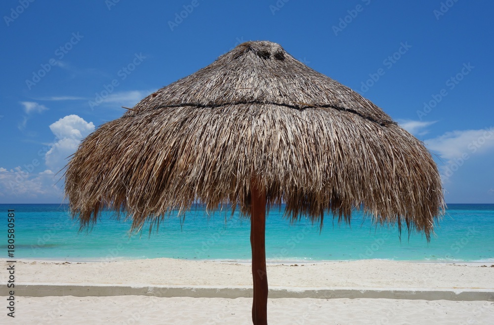 A palapa thatched palm tree sun umbrella on the beach in Cancun, Mexico ...
