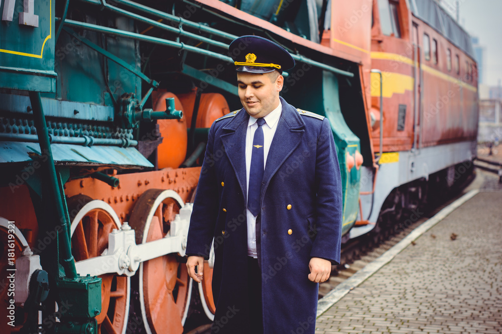 European or American train conductor is on his duty on a platform and ...