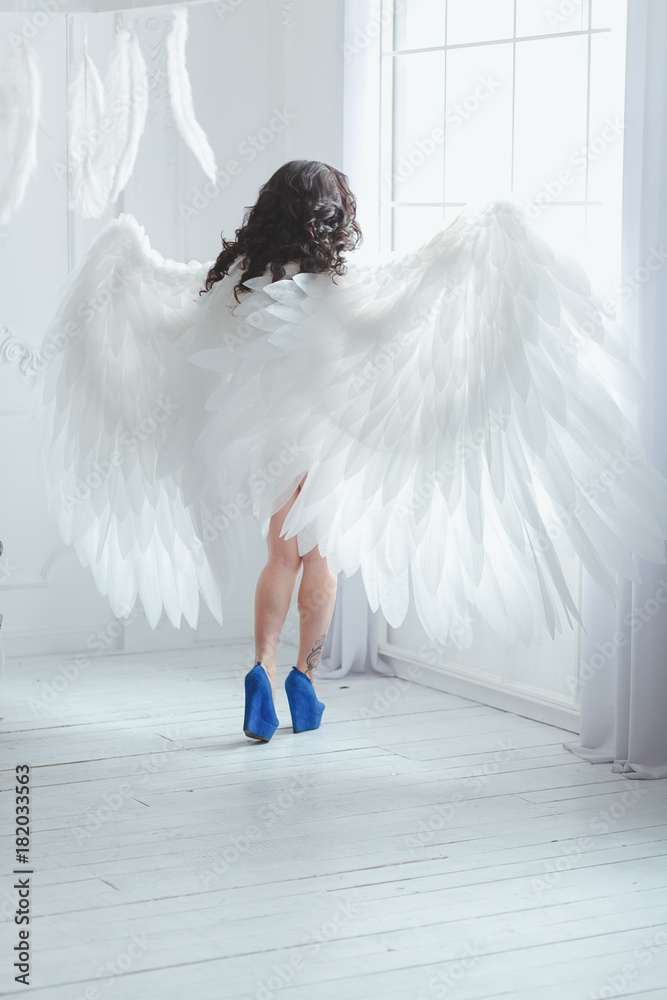 Beautiful young brunette pregnant girl with big angel wings in white ...