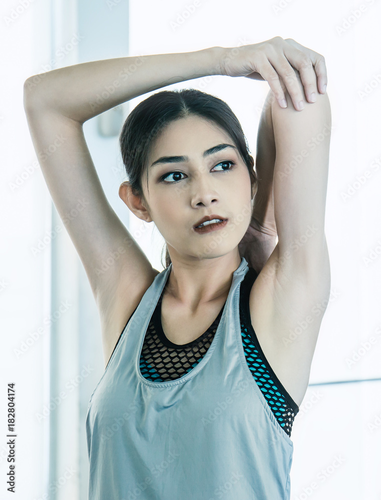 Portrait of asian fitness woman doing warm up exercises indoor, Close up Asian athlete woman ...