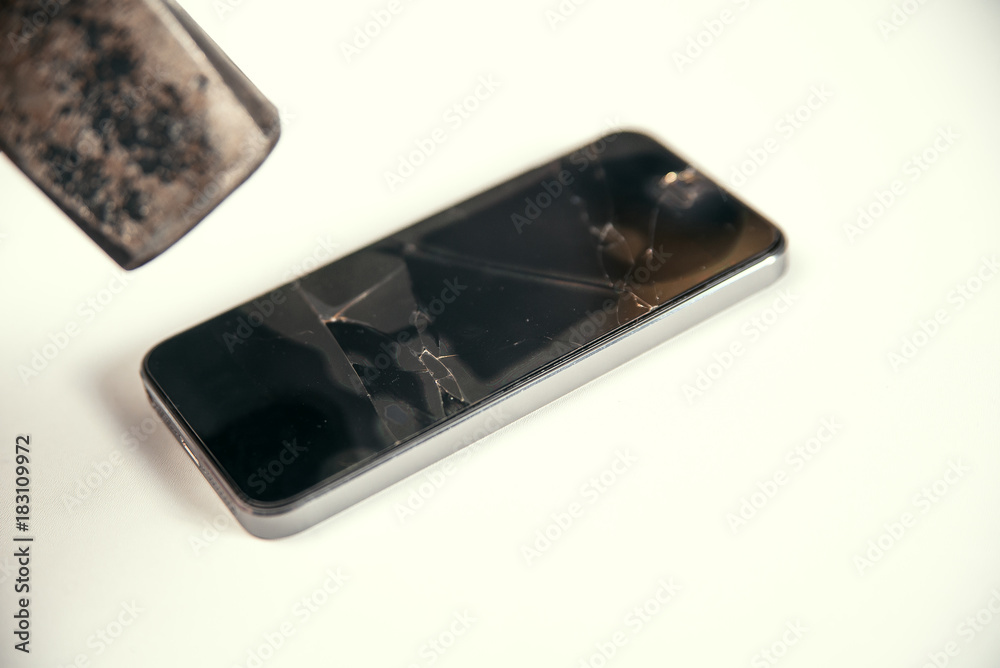 Big hammer breaks the screen of a modern smartphone. Broken glass ...
