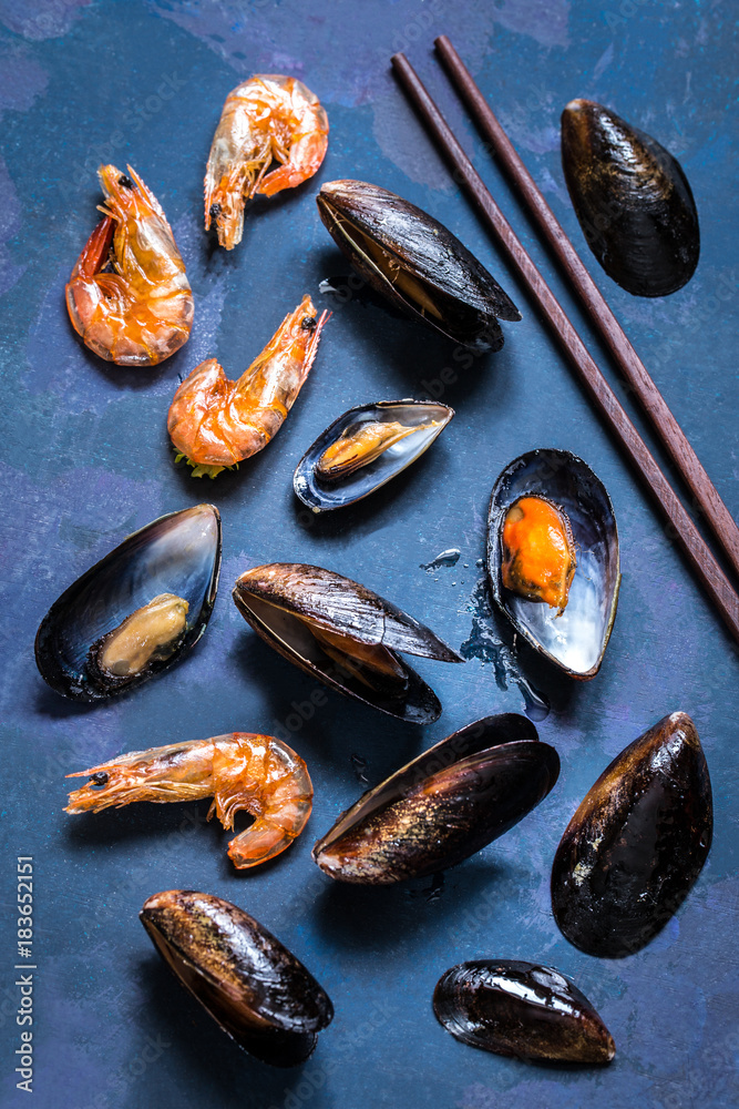 Seafood mussels in the shell and shrimp on a blue background grill ...