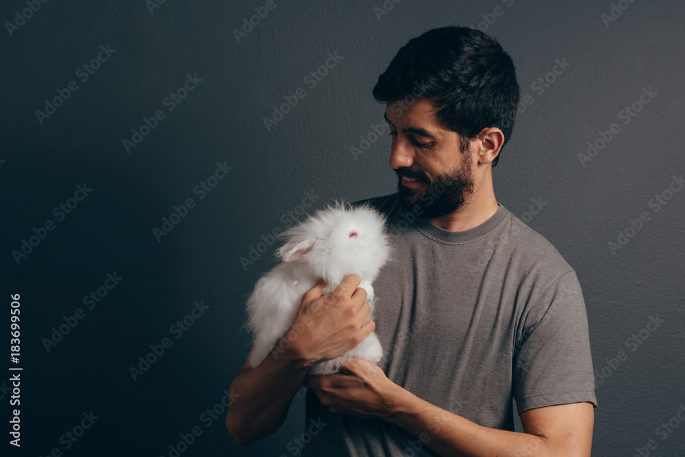 Adorable bunny in hands. Cute pet rabbit being cuddled by his owner ...