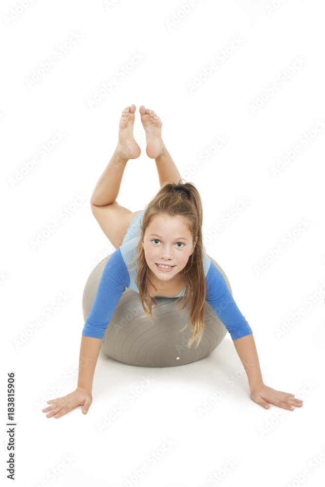 Young girl doing stretching gymnastic exercises sitting on a large ...