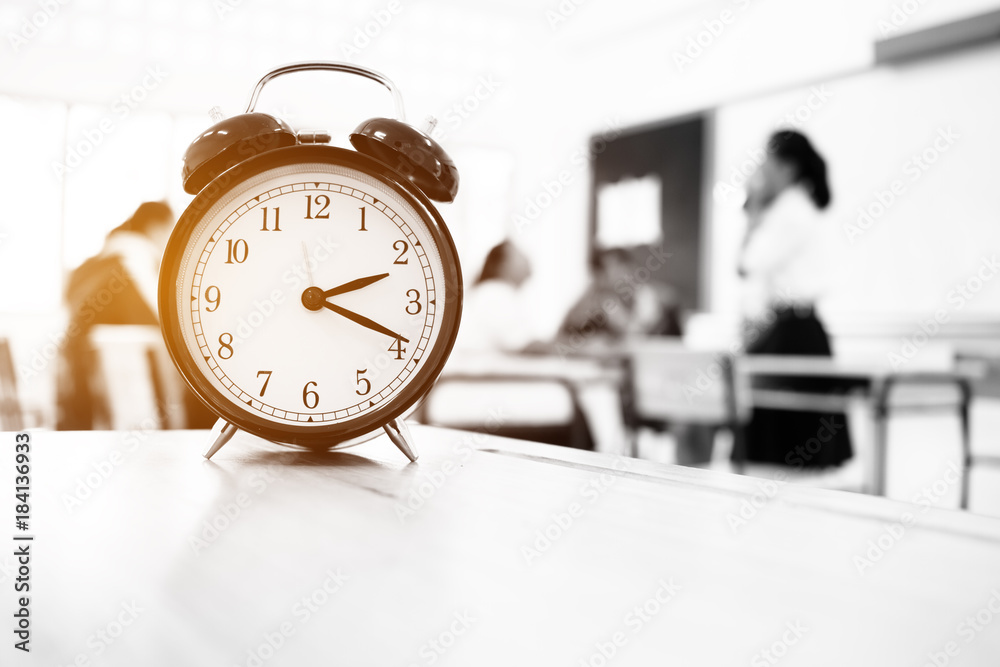 Alam clock located on wood teacher table in final exam room of ...