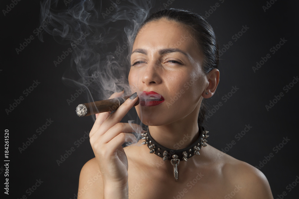 Topless brunette woman smoking big cigar. Stock Photo | Adobe Stock