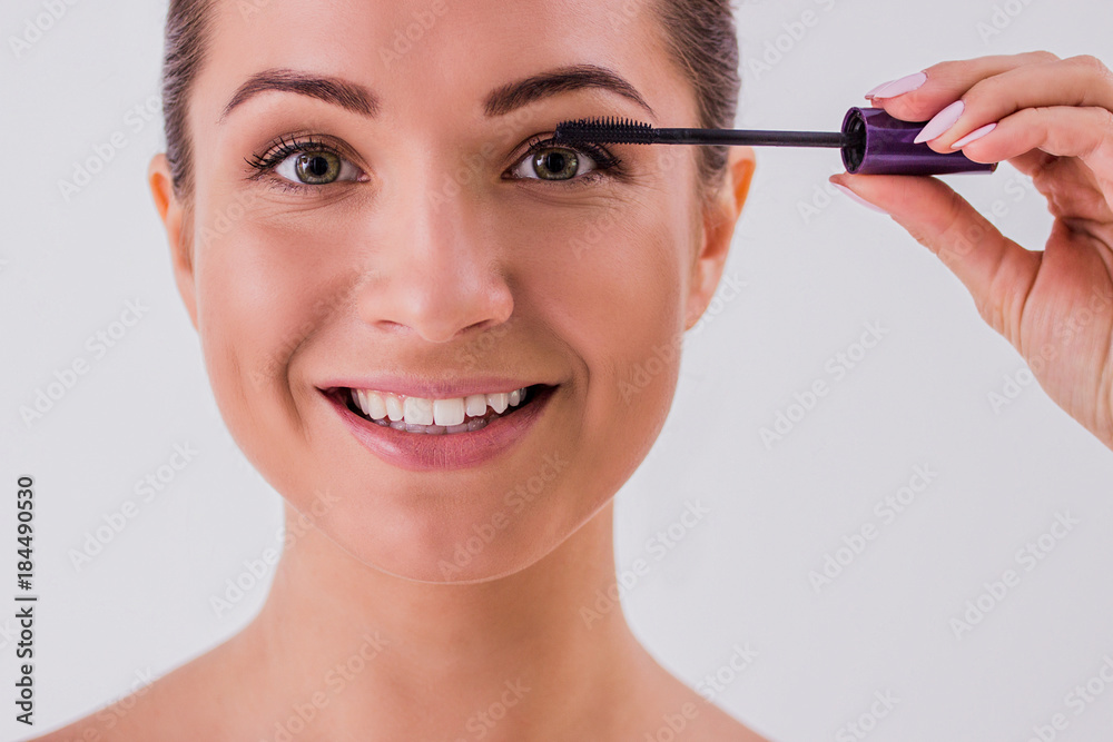 Accentuating her beautiful eyes. Close up of shirtless woman applying ...