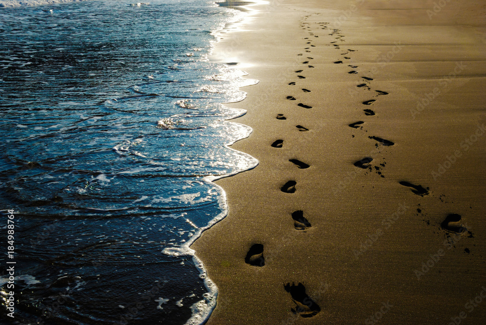 Two pairs of footprints in the sand on the beach Stock Photo | Adobe Stock