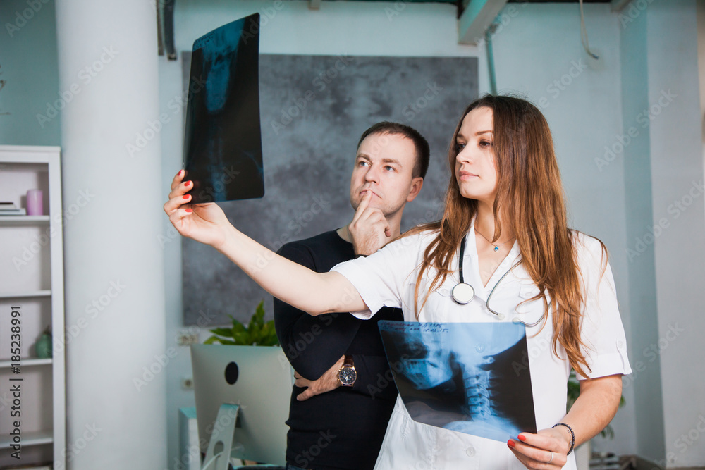 Young professional female doctor showing x-ray of human scull during ...