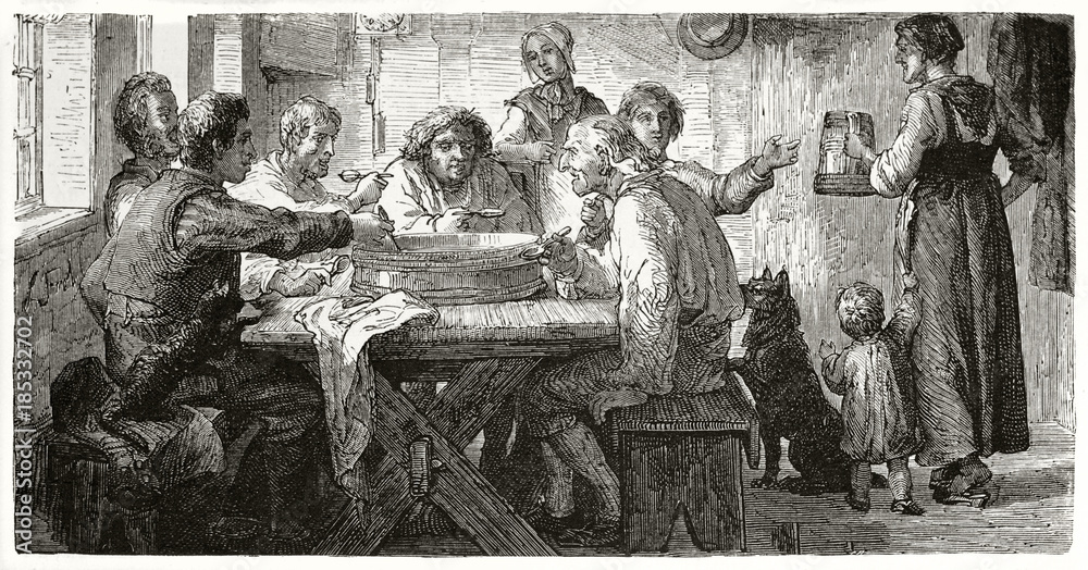 Ancient poor farmers seated on a wooden table eating all from a sole ...