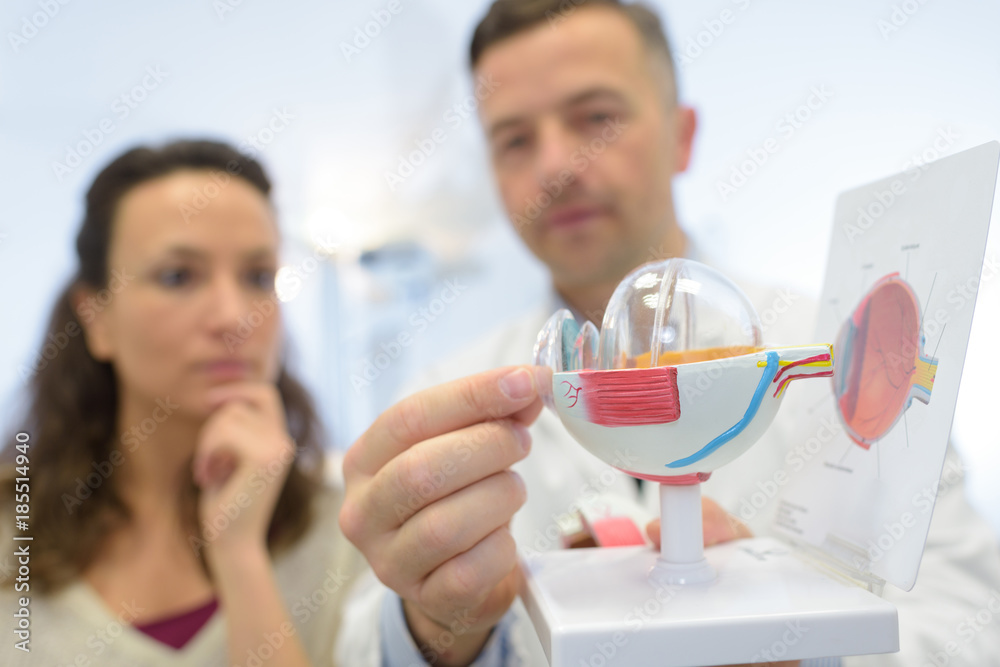 optometrist explaining how the eyes are working to female patient Stock ...