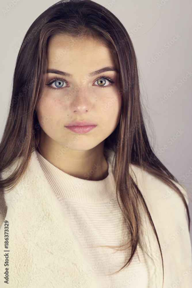 Photo Stock Portrait d' une belle jeune fille brune aux yeux bleus | Adobe Stock