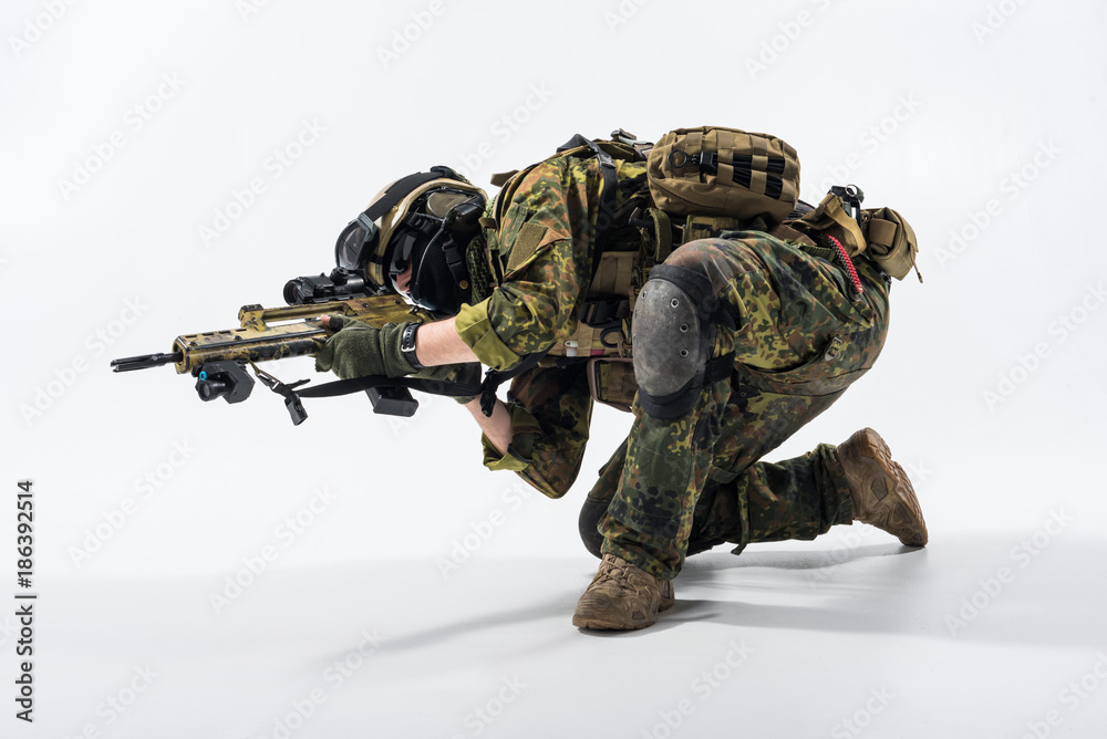 Full length severe soldier shooting firing with assault carbine. War ...