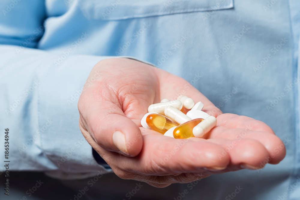 Woman take in the hand variety medication pills, yellow capsules of ...