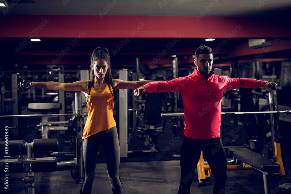 Attractive shape young sporty focused fitness girl doing shoulder ...