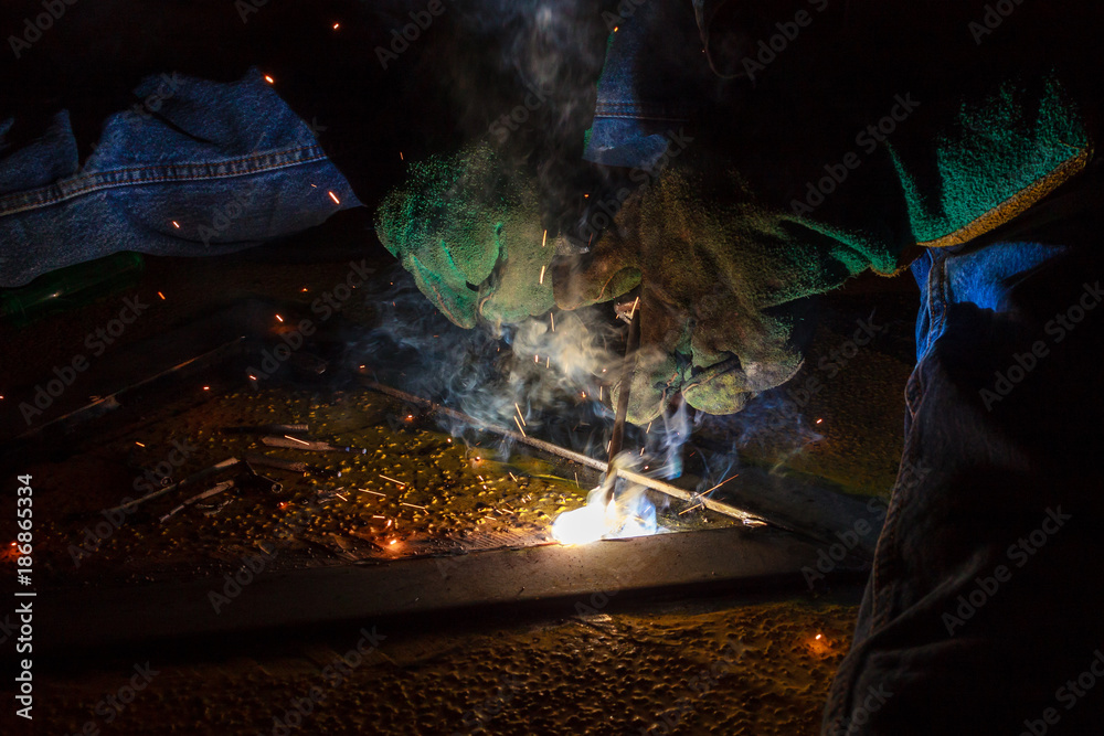 Welder perform welding to the metal plate at roof floor of ...