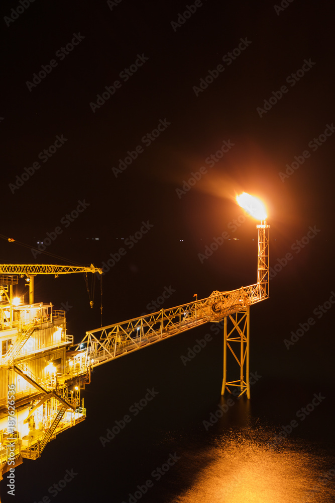 Offshore oil and gas flare blowout in the sea during storm background ...