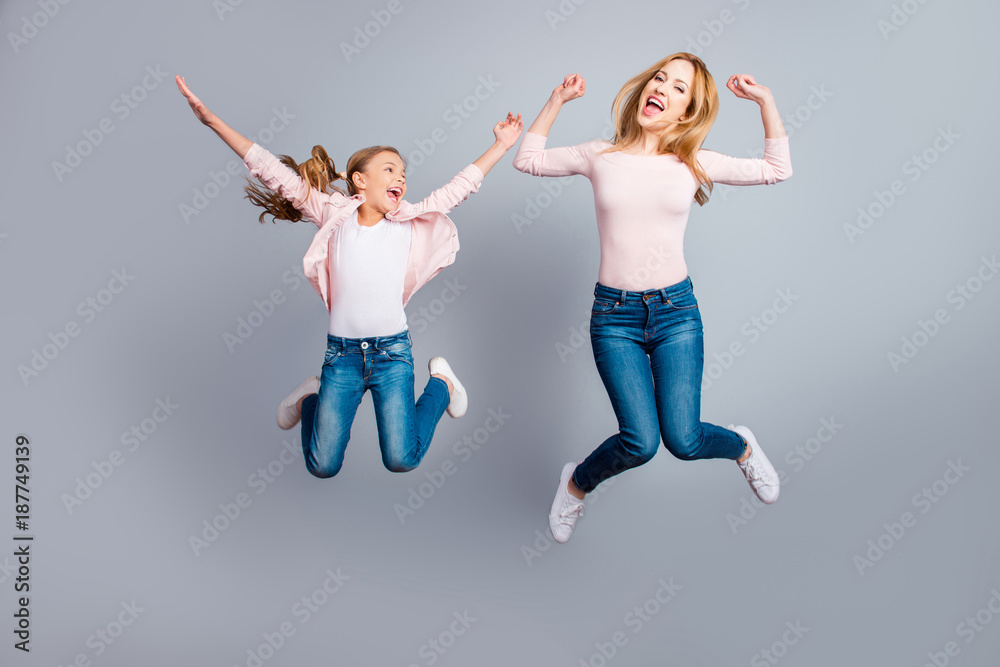 Cute, pretty, playful mother and daughter with open mouth jumping in ...