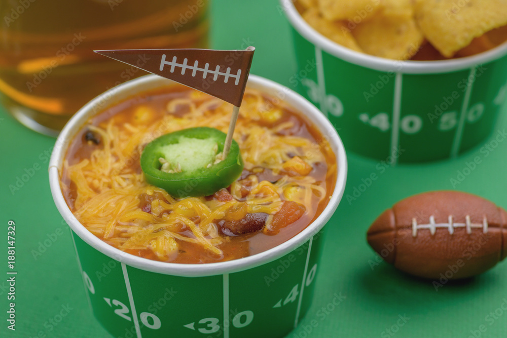 close up of bowl of chili with jalepeno pepper and football flag on top ...