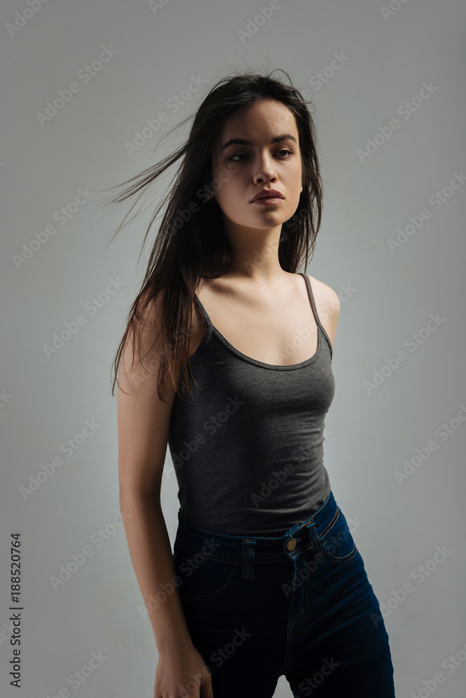 Young. Beautiful stony-faced dark-haired young woman thinking and ...