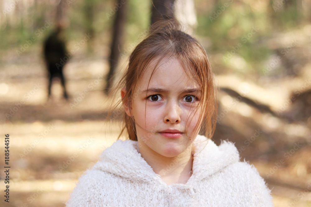 Frightened little girl alone in the forest with dark silhouette at ...