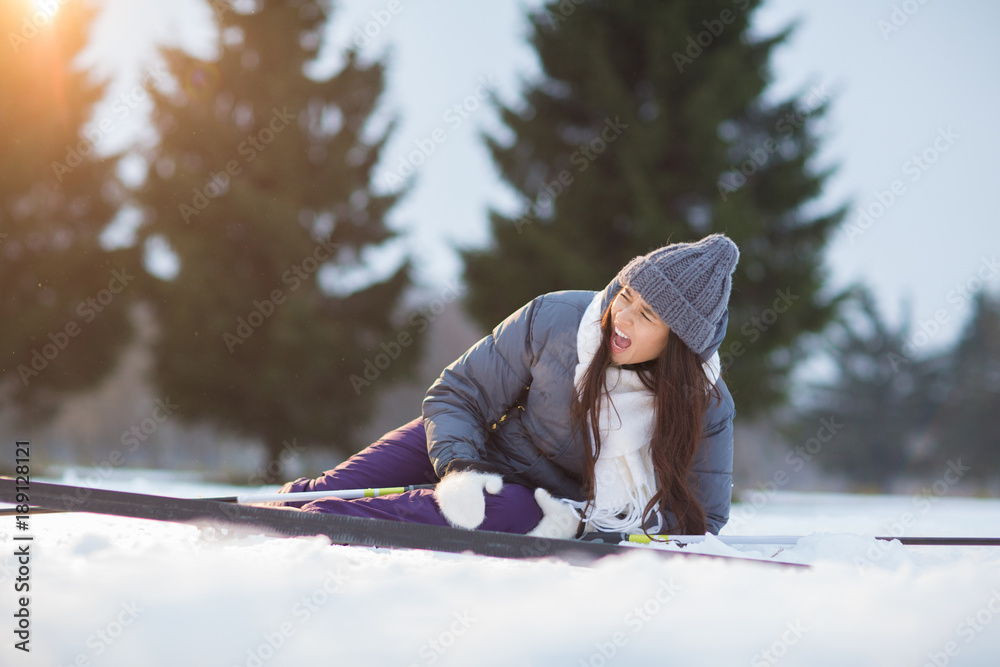 Young woman screaming from pain in her leg or knee after falling down ...
