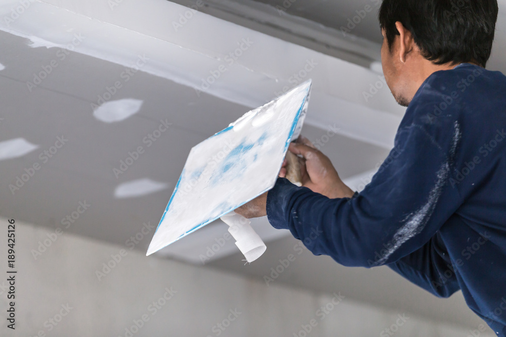 Construction man worker plaster gypsum ceiling for interior build ...