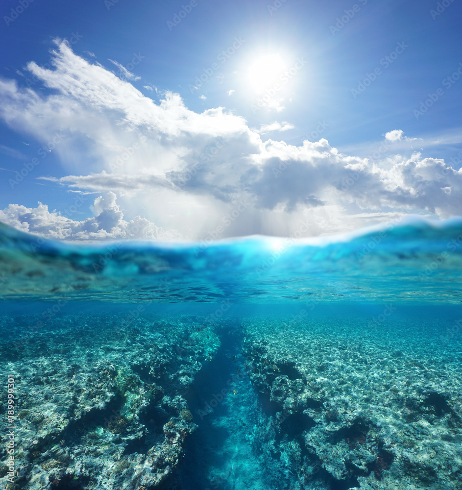 Over and under water surface seascape, sunlight with cloudy blue sky ...