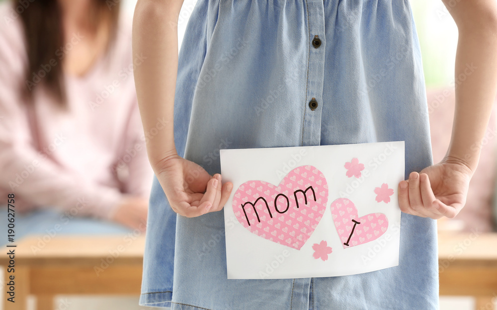 Little girl hiding greeting card for mommy behind her back on Mother's ...