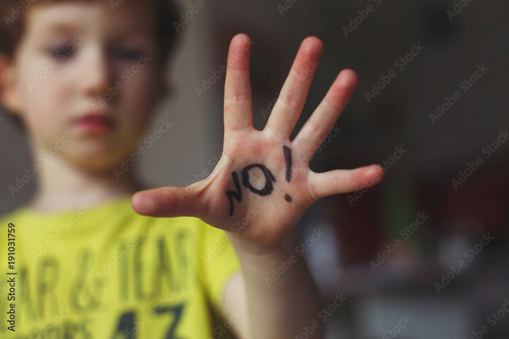 3 years old boy making a stop signal with his hand. Word No writing on ...