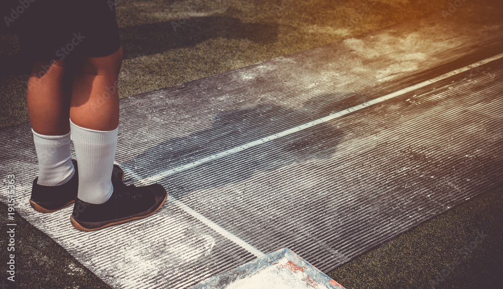 Students boy taking long jump on rubber board during a school sport ...