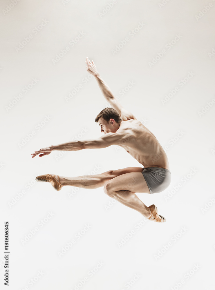 The male athletic ballet dancer performing dance isolated on white ...