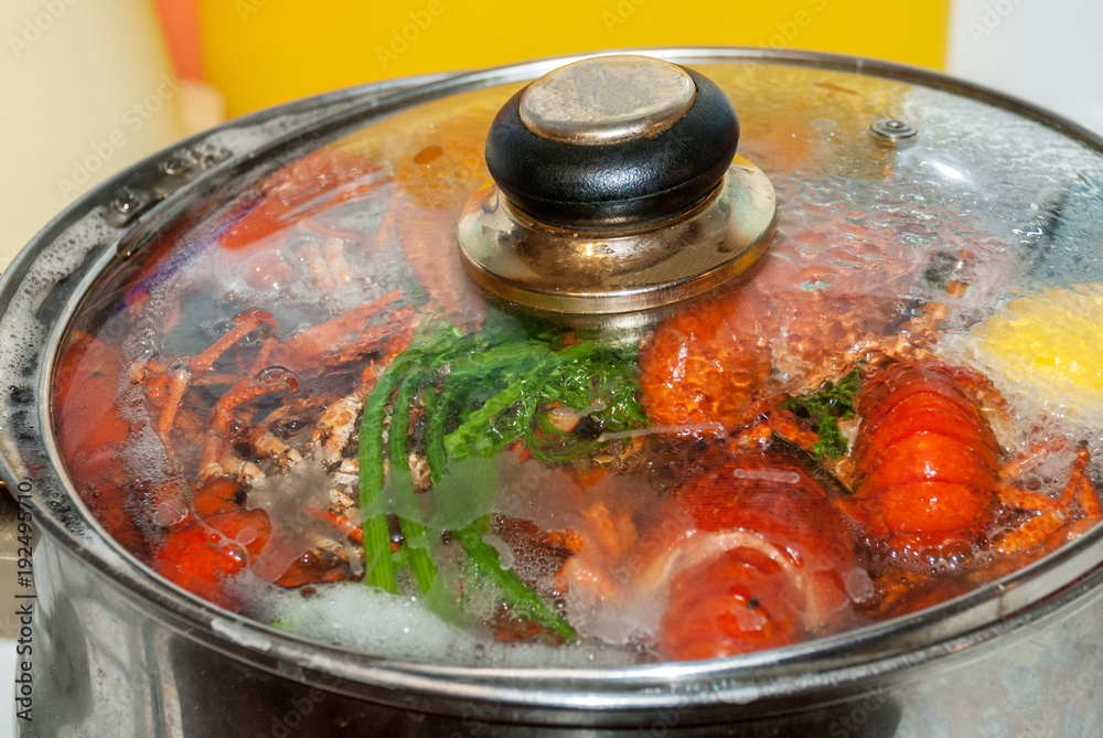 Fresh red crayfish are cooked in a pot of boiling water with lemon and ...