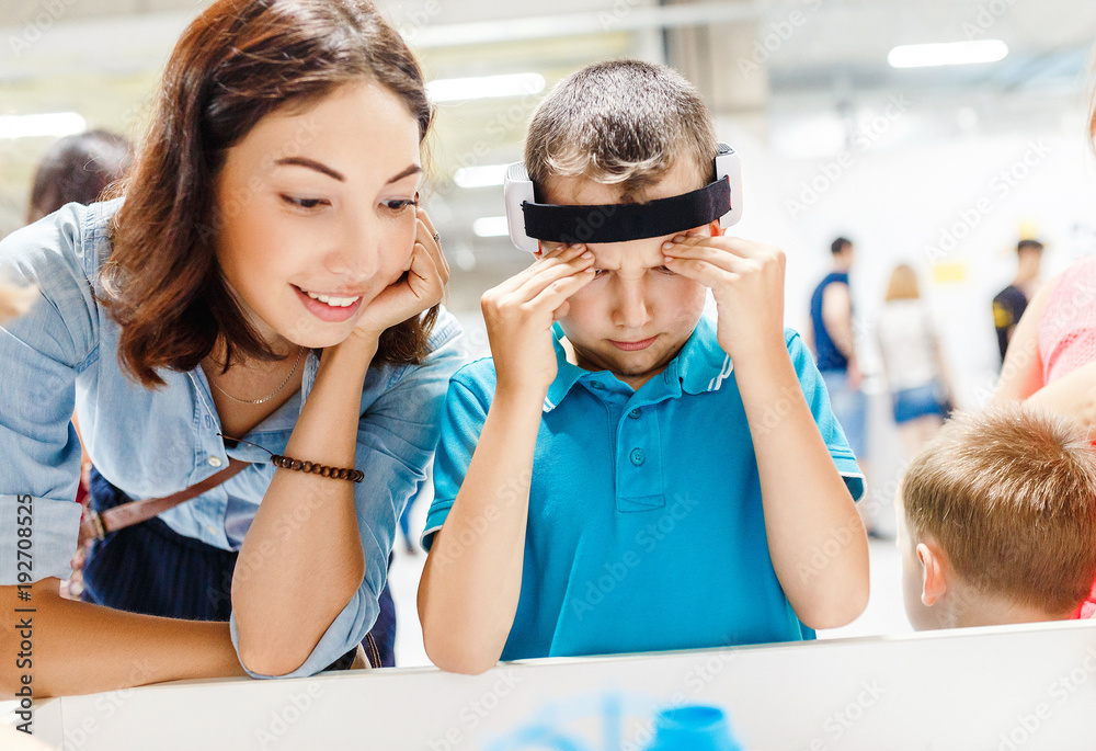 Boy with digital headset sensor connected to his brain, reading ...