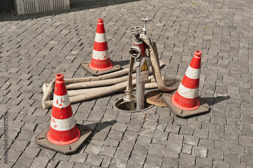 Pilonen sichern einen Unterflur-Hydrant mit einem montierten Standrohr ...
