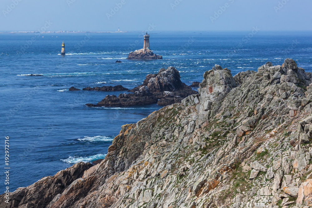 Rocky promontory Pointe du Raz and old lighthouse Phare de la Vieille ...