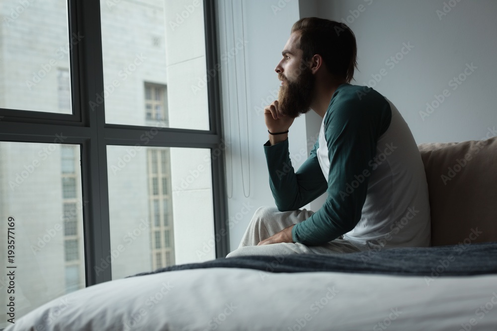 Man looking through window in bedroom Stock Photo | Adobe Stock